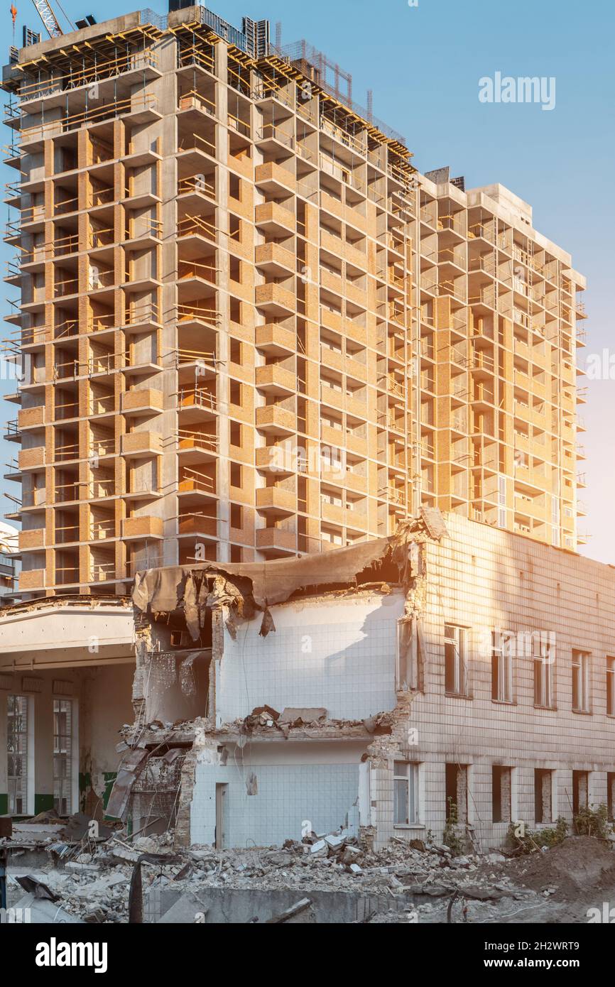demolition of old building near new construction of modern skyscraper ...