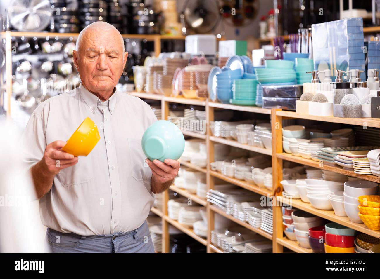 Mature man choosing new dishes at store Stock Photo - Alamy