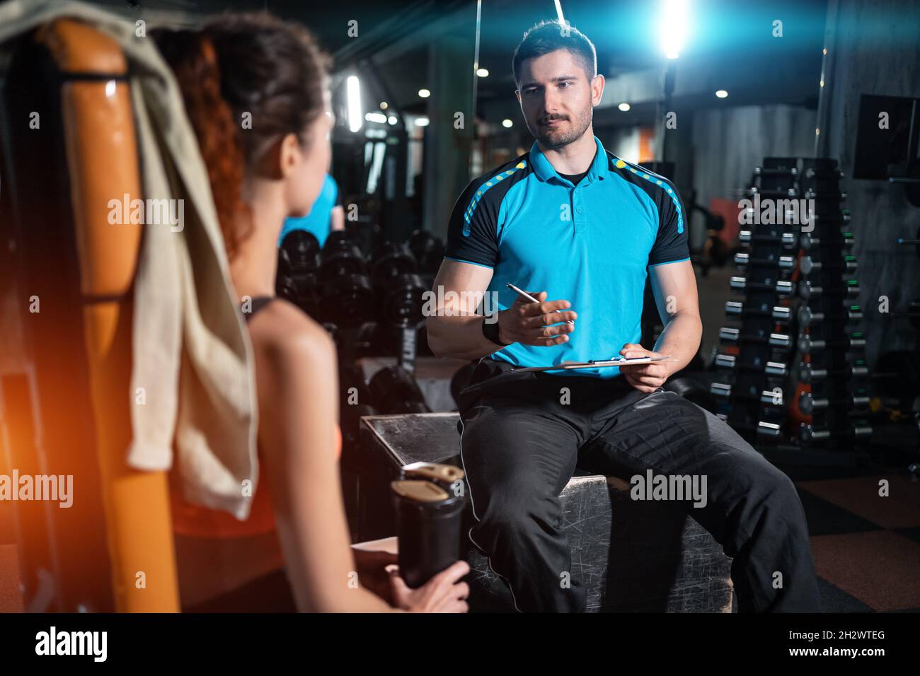 young personal trainer man talking with woman athlete and plan workout ...