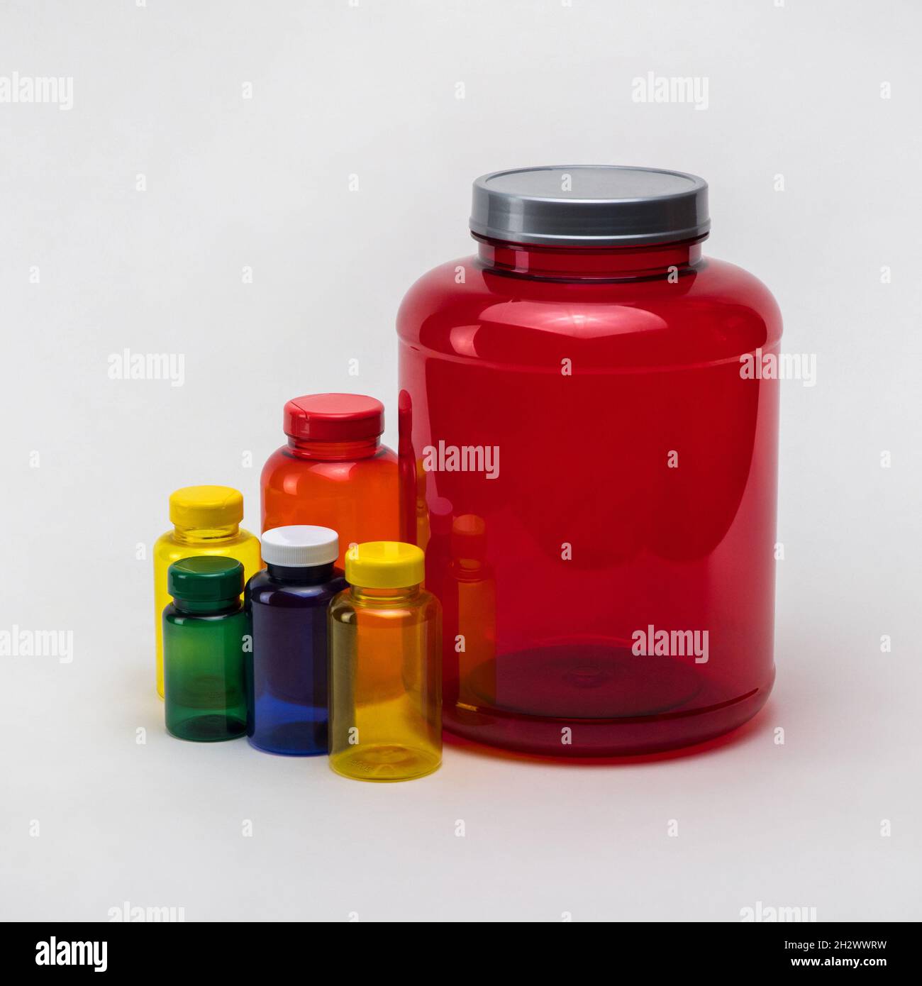 Multi colored transparent plastic pill jars on a white background ...