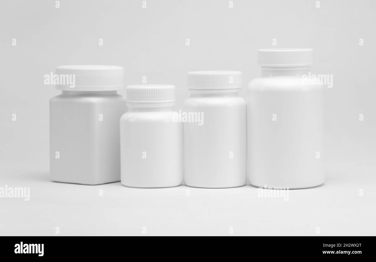 White plastic pill jars on a white background. Isolated Stock Photo - Alamy