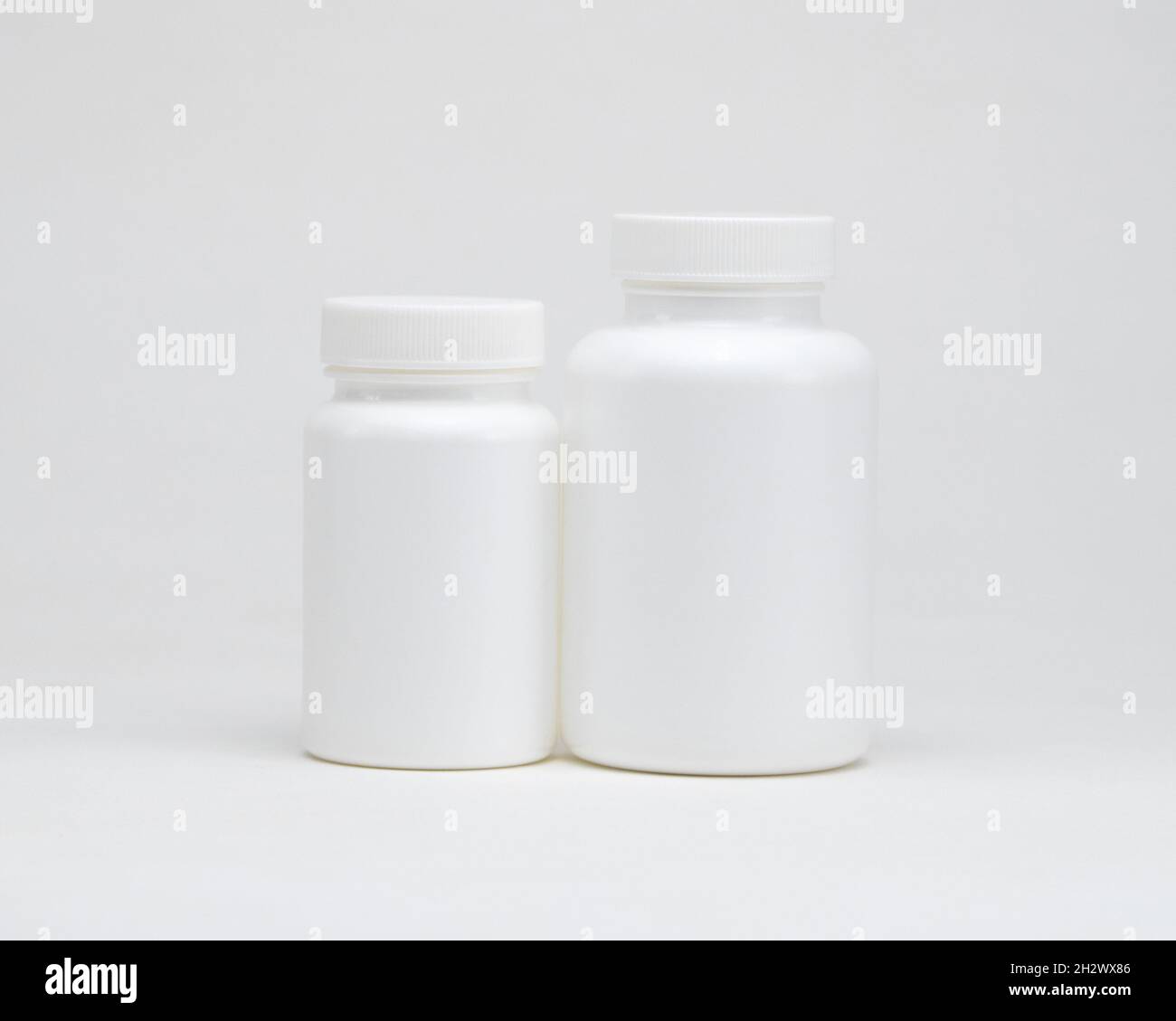 White plastic pill jars on a white background. Isolated Stock Photo - Alamy
