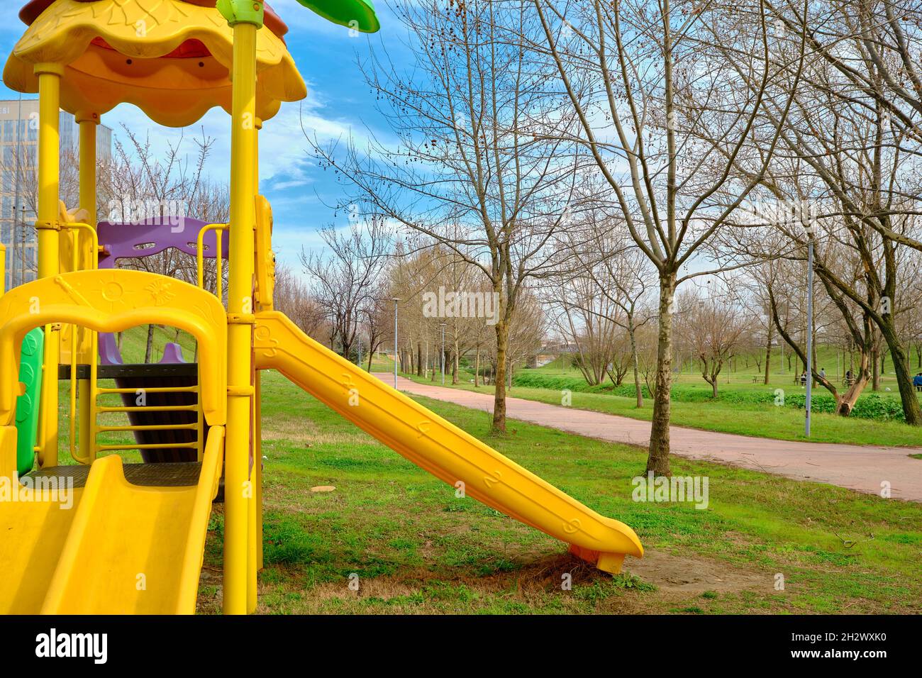 Colorful playground on green grass and walking path Stock Photo - Alamy