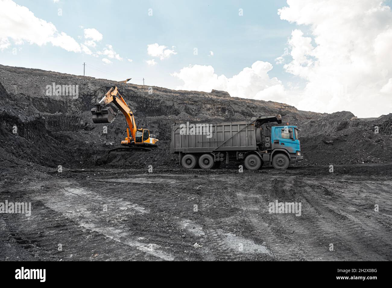 Large quarry dump truck. Loading the rock in dumper. Loading coal into body truck. Production ...