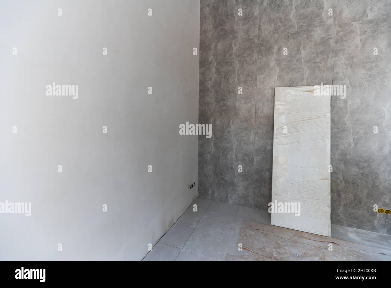 The wall of the building is covered with fresh plaster and surrounded ...