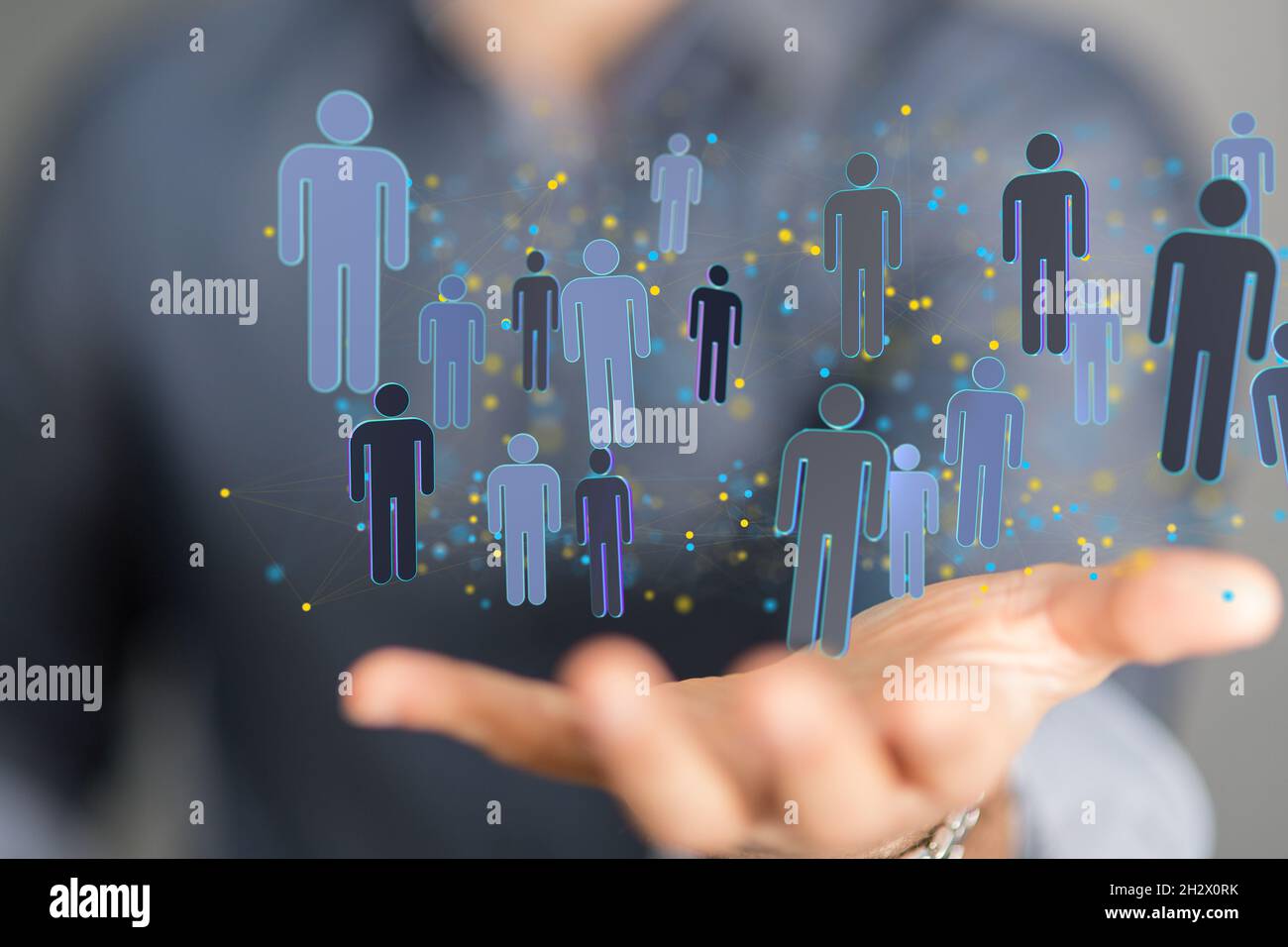 A male's hand holding illustrated business people silhouettes network ...