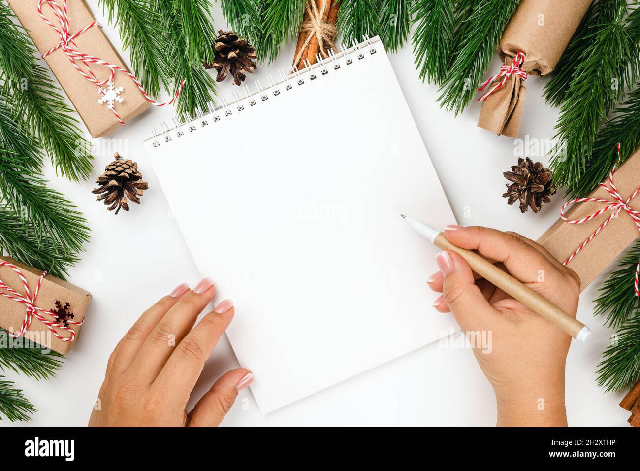 flat lay Christmas frame with decorations, woman hands write letter to ...