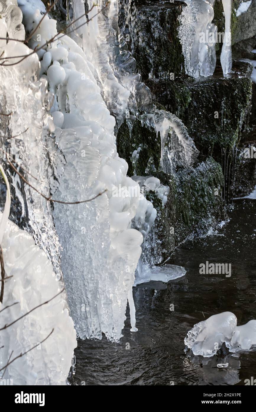 Icicle formation at the bottom of frozen cascade in winter Stock Photo ...