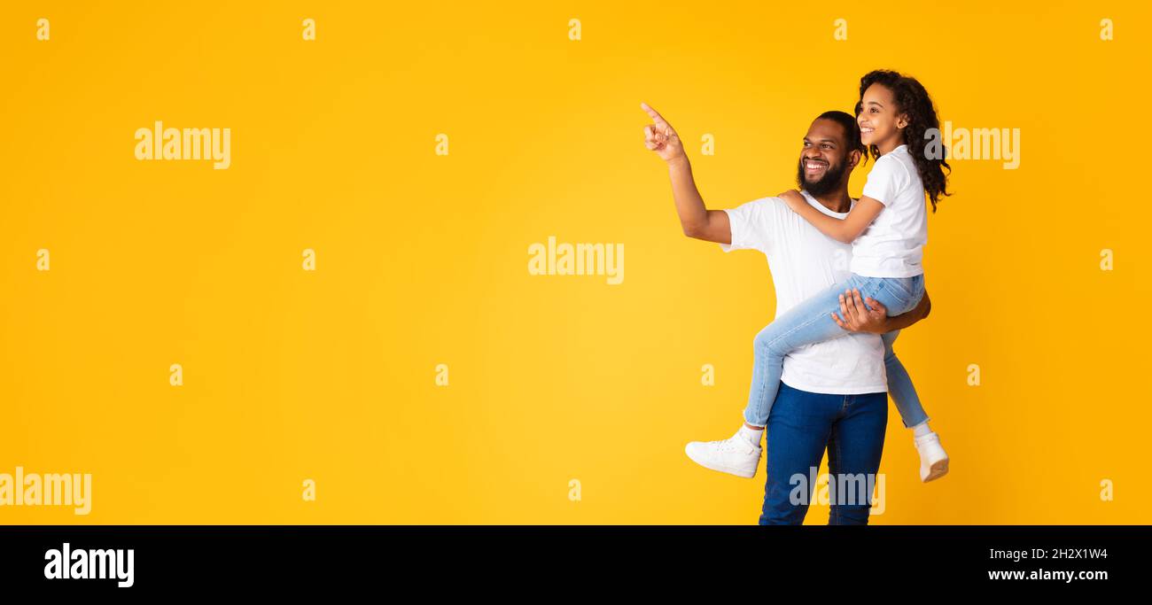 Smiling black dad pointing aside at copy space at studio Stock Photo ...