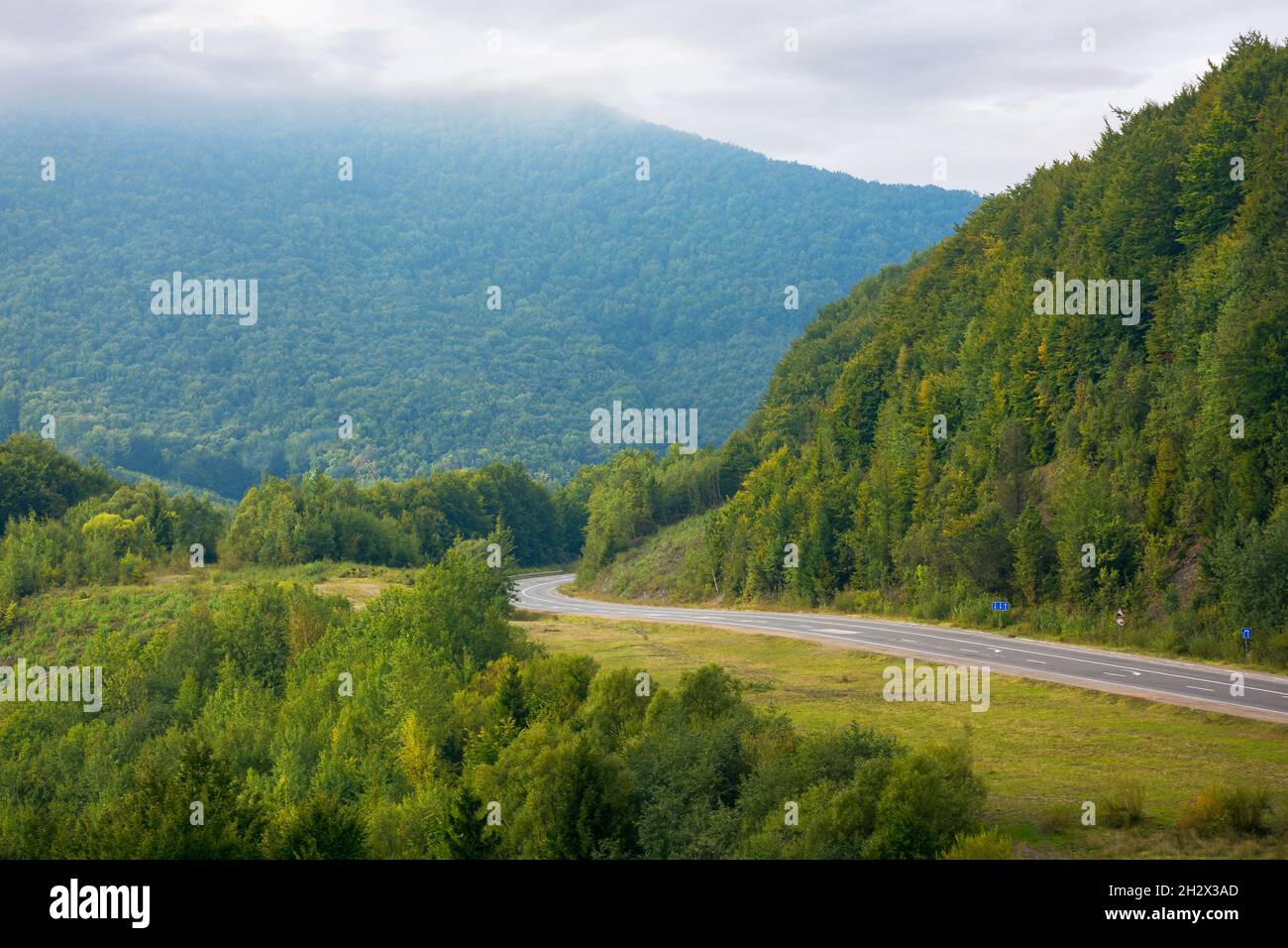 mountain road through countryside on a cloudy morning. beautiful ...