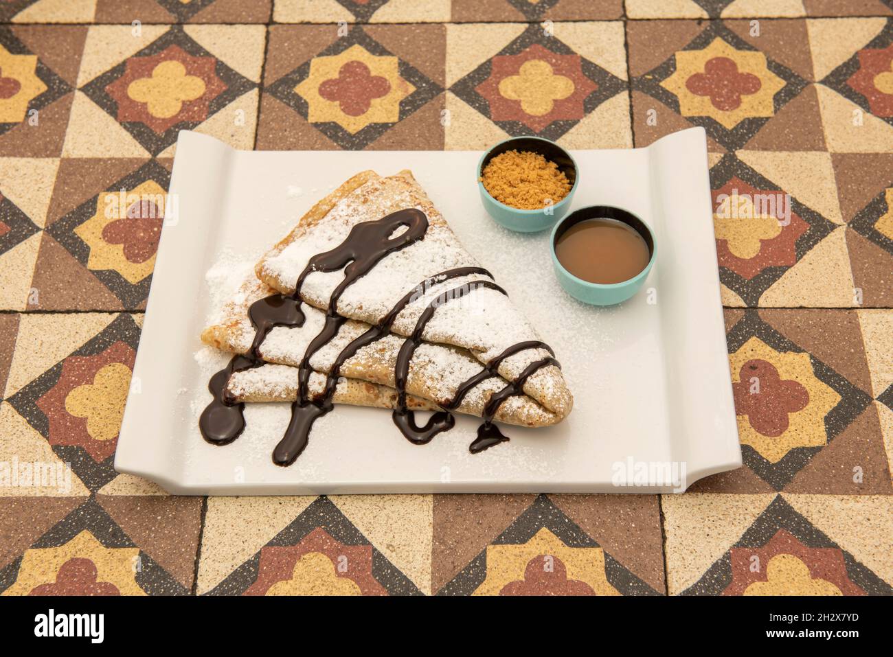 Sweet chocolate crepe with syrup, icing sugar, biscuit earth and maple ...