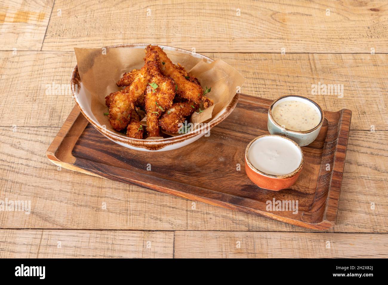 Delicious serving of crispy battered chicken strips with cheese sauces ...