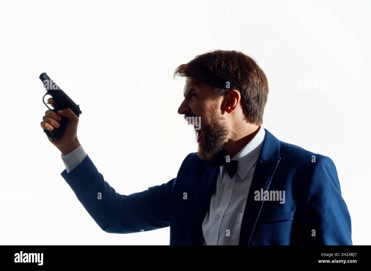 male Agent with a gun in hand Studio emotions Stock Photo - Alamy