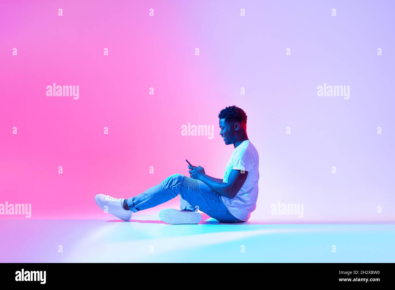 Cool mobile app. Side view of happy black man using modern smartphone ...