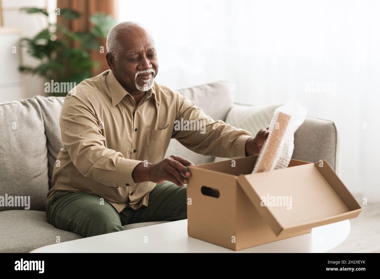 Retired Senior African American Man Packing Stuff In Box Indoors Stock ...