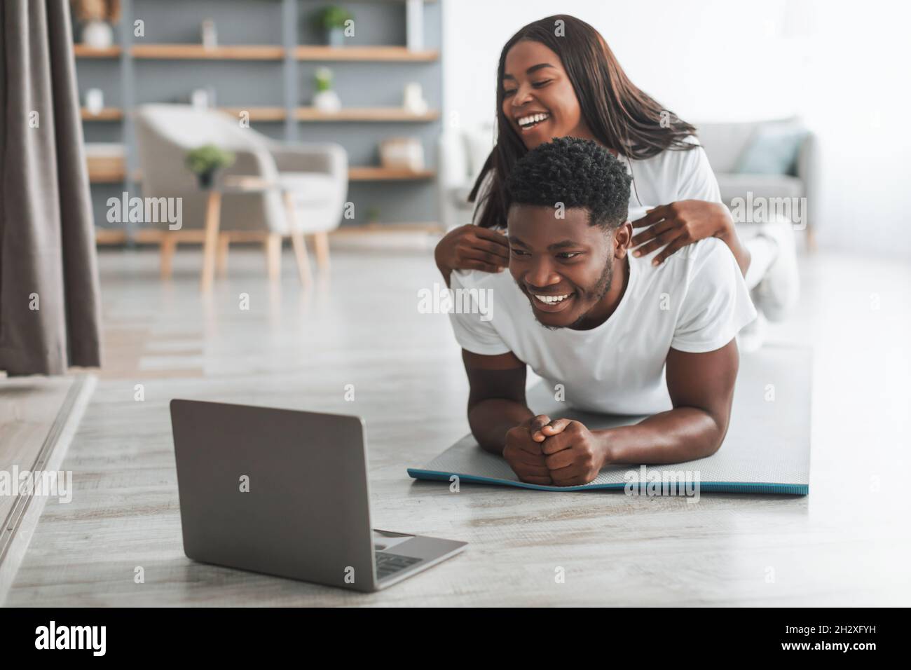 Young black couple planking in front of laptop at home Stock Photo - Alamy