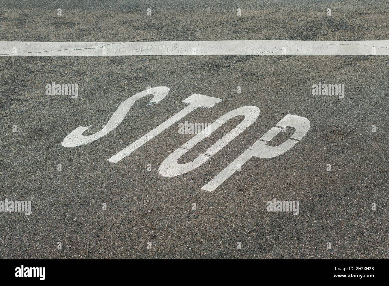 A high angle shot of a stop sign on the road as an obligatory traffic ...