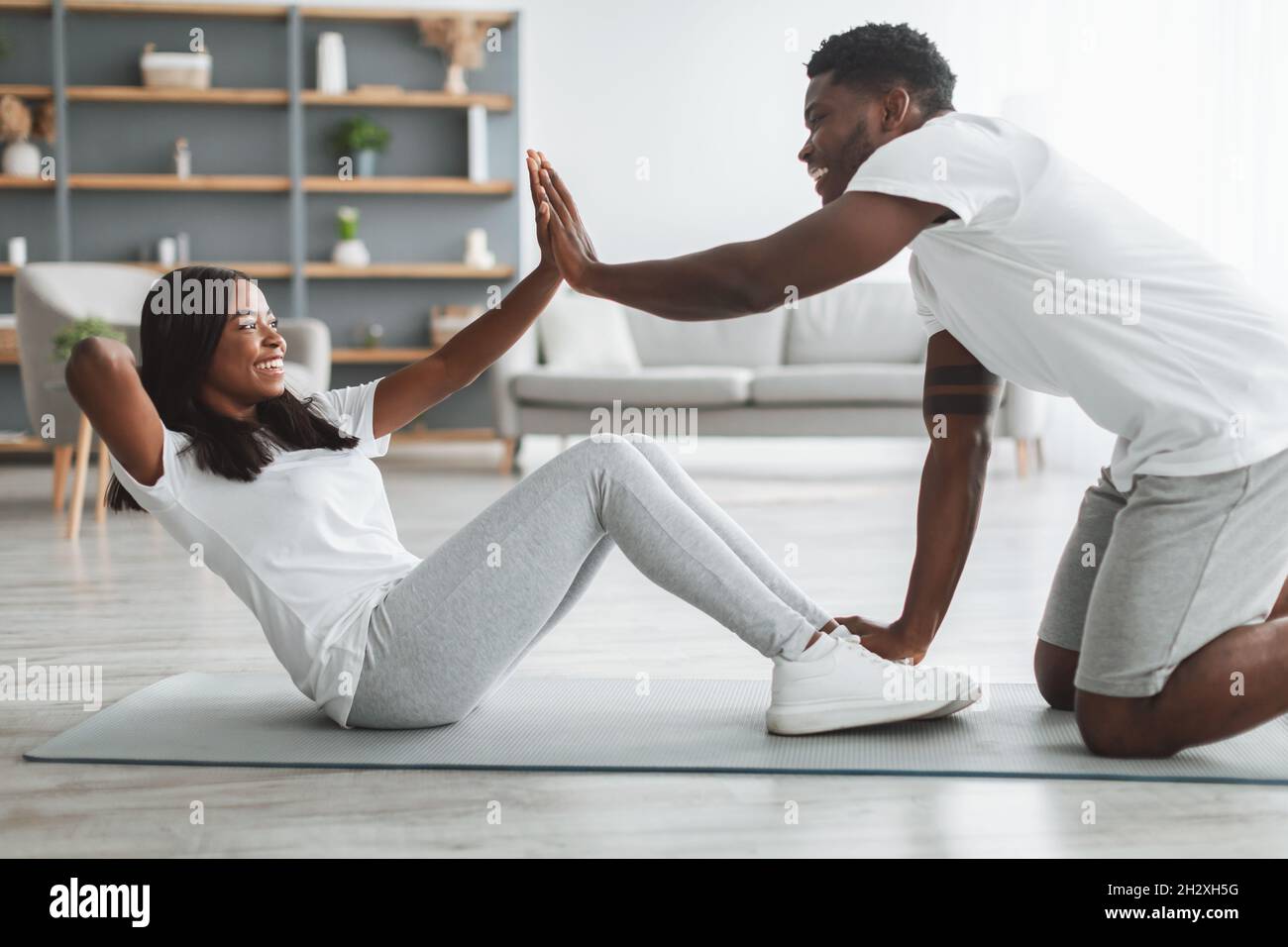 Young black couple doing crunches exercise on abs Stock Photo - Alamy