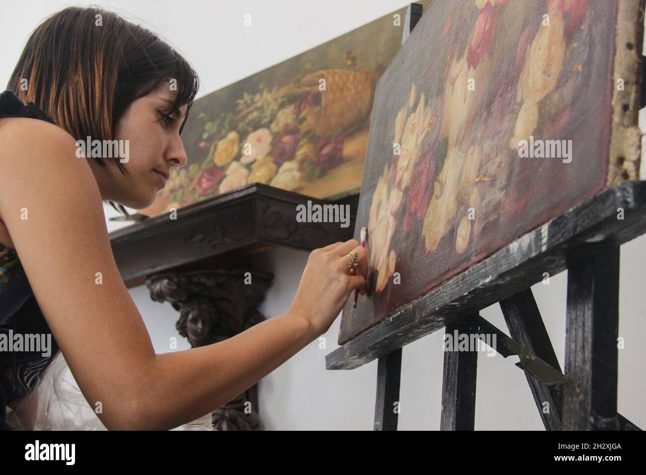 A closeup shot of a Hispanic female painting in an art studio Stock ...