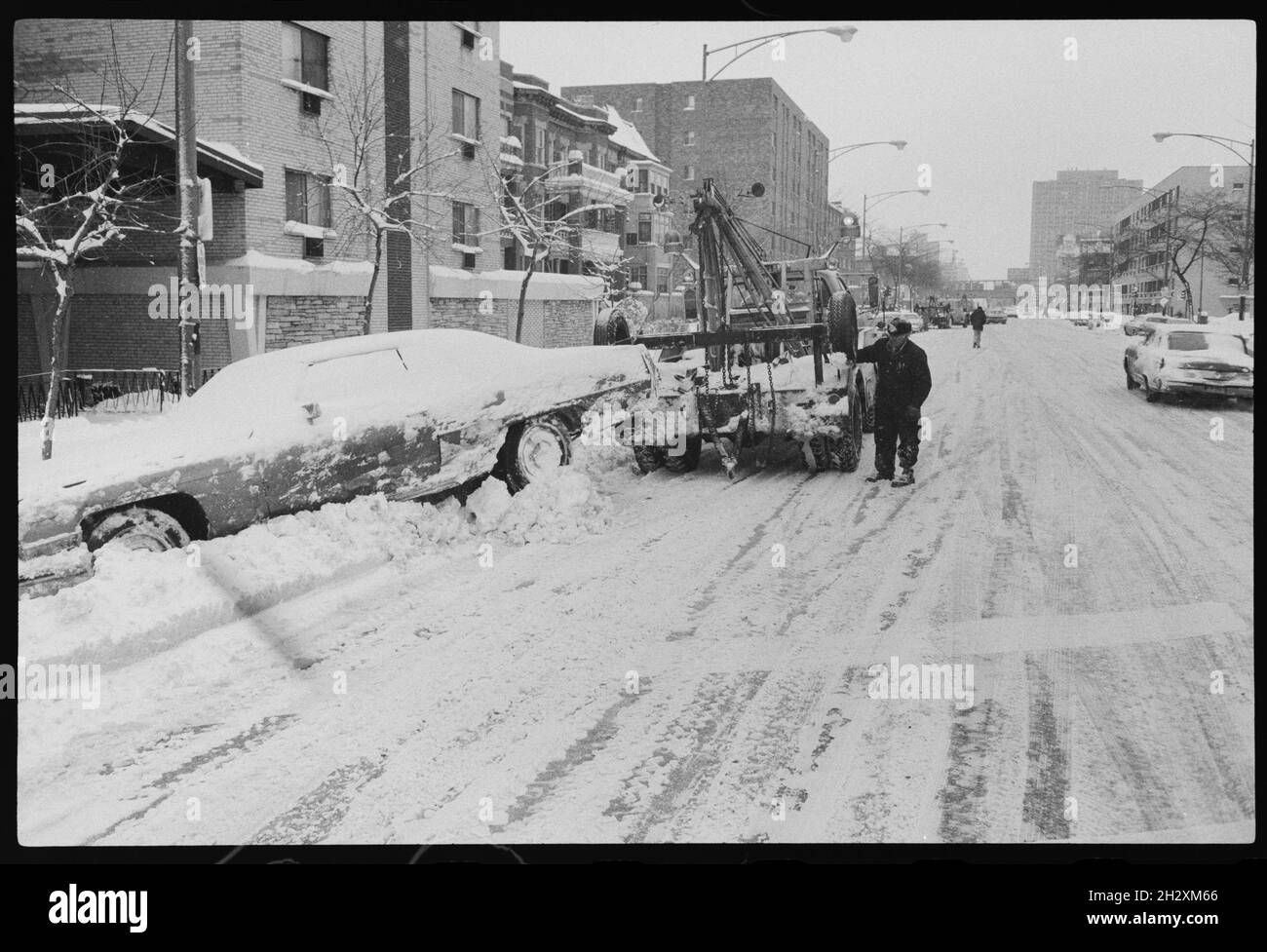 Blizzard Tow Truck operator pulls out a stuck car from the snow ...