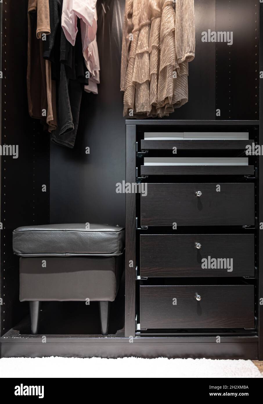 Black wardrobe, locker and pouf, inside view Stock Photo - Alamy