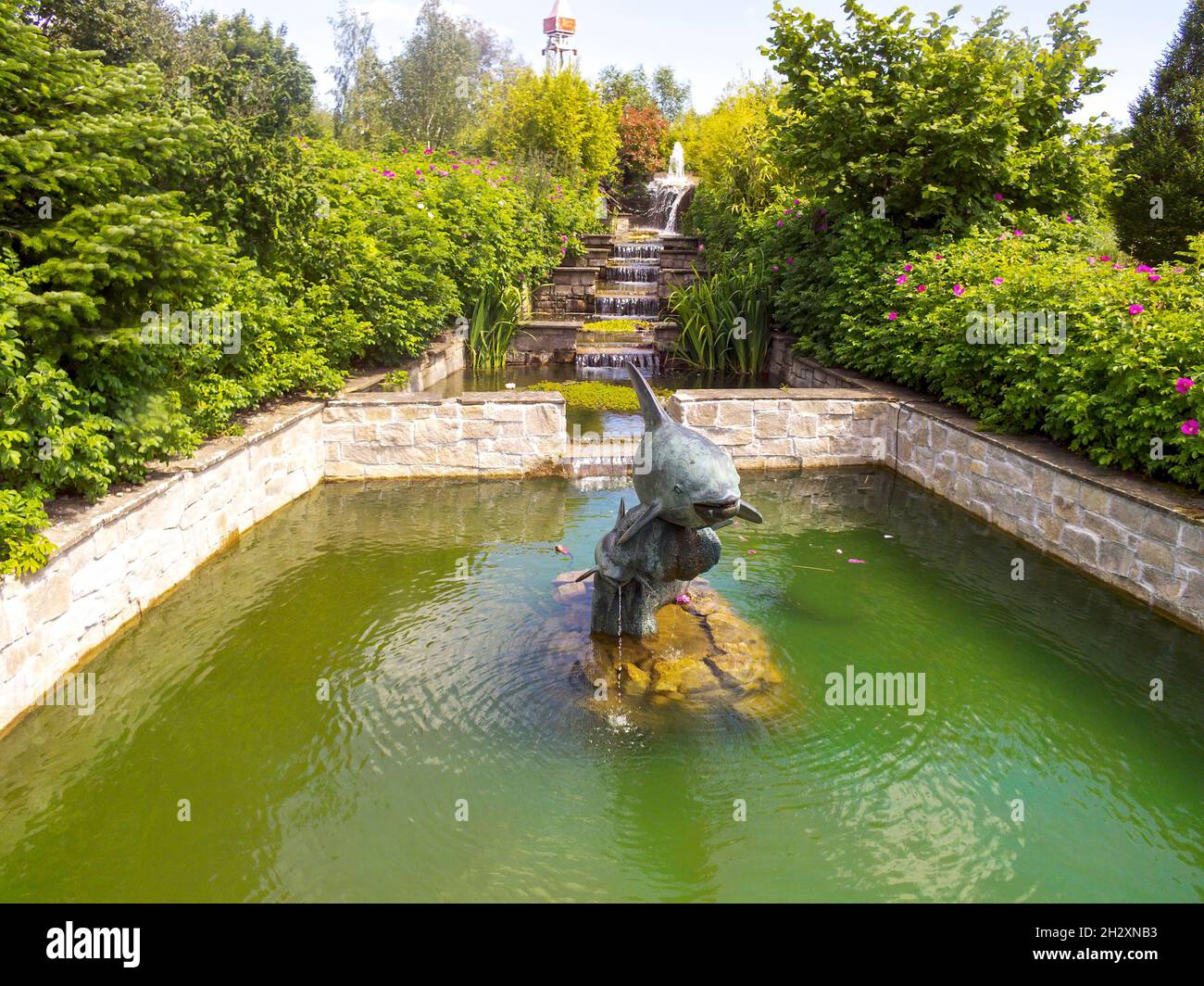 Dolphin sculpture in the artificial pond with cascades behind Stock ...