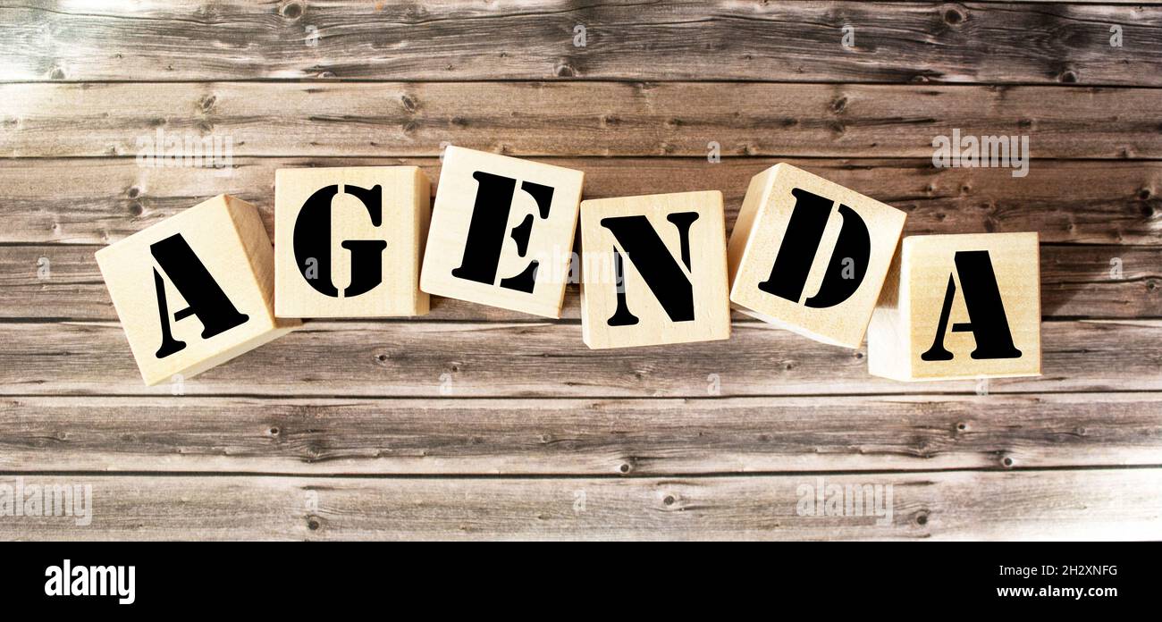 Agenda - words made of wooden blocks with letters, list of questions on ...