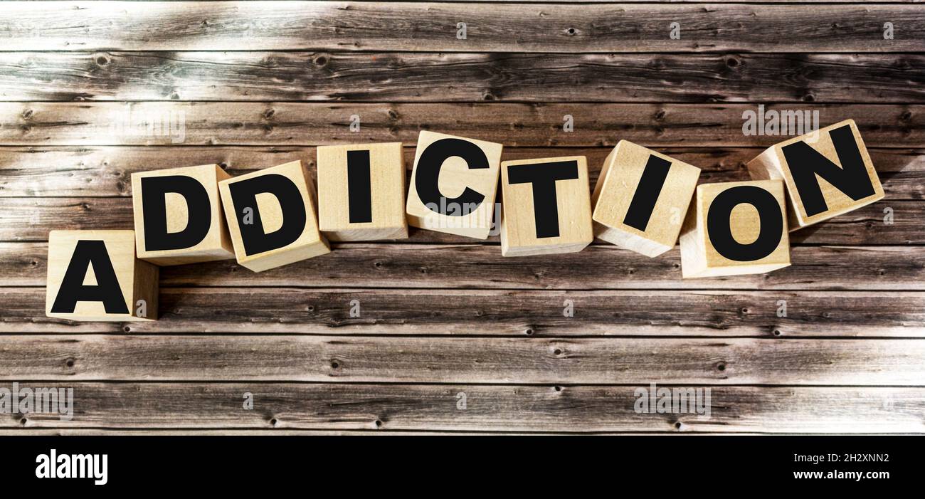 The word addiction made of wooden letters lies on a brown background ...