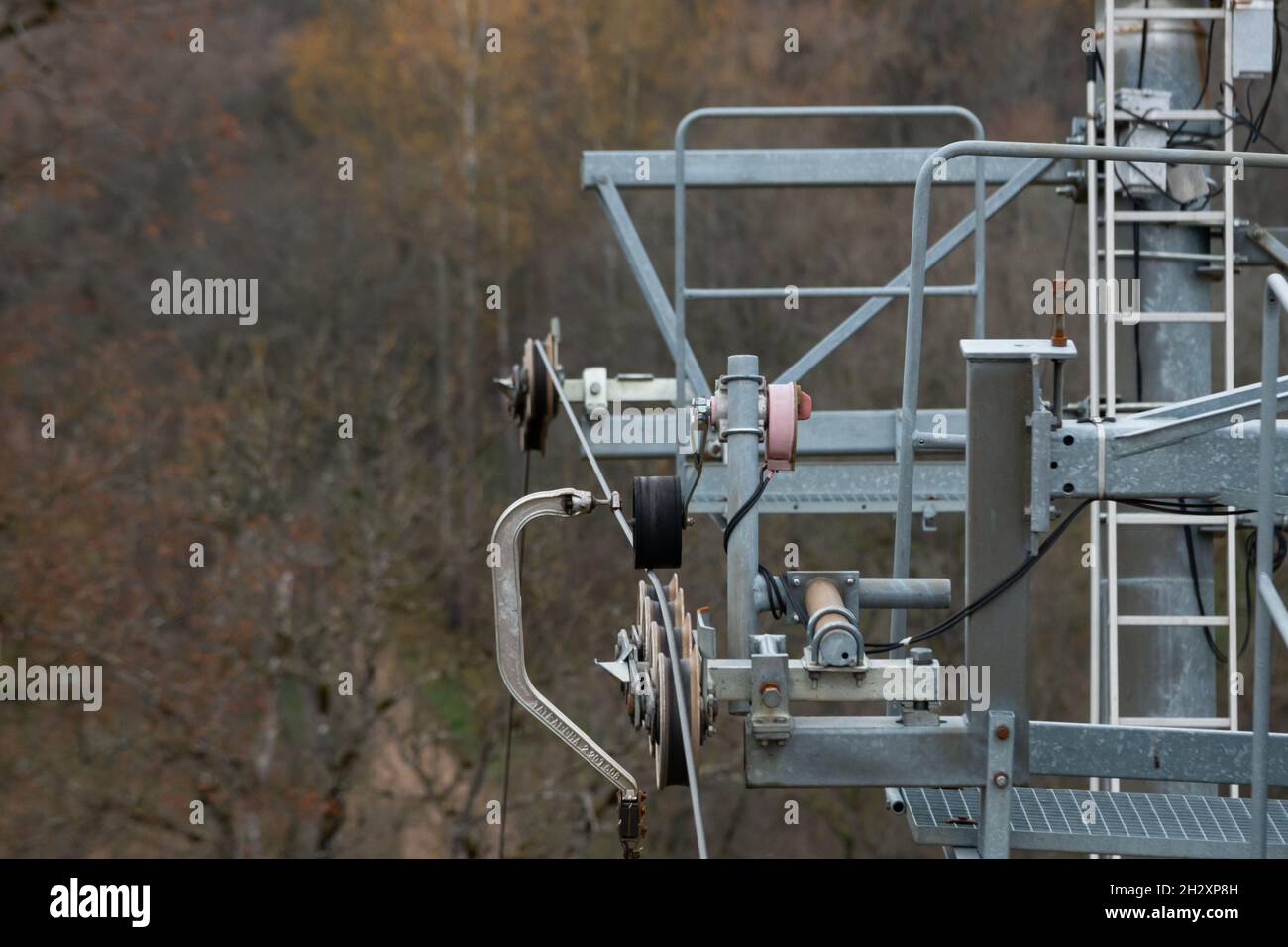 Close-up of a metal ski lift with a rusty metal wire on an autumn day ...