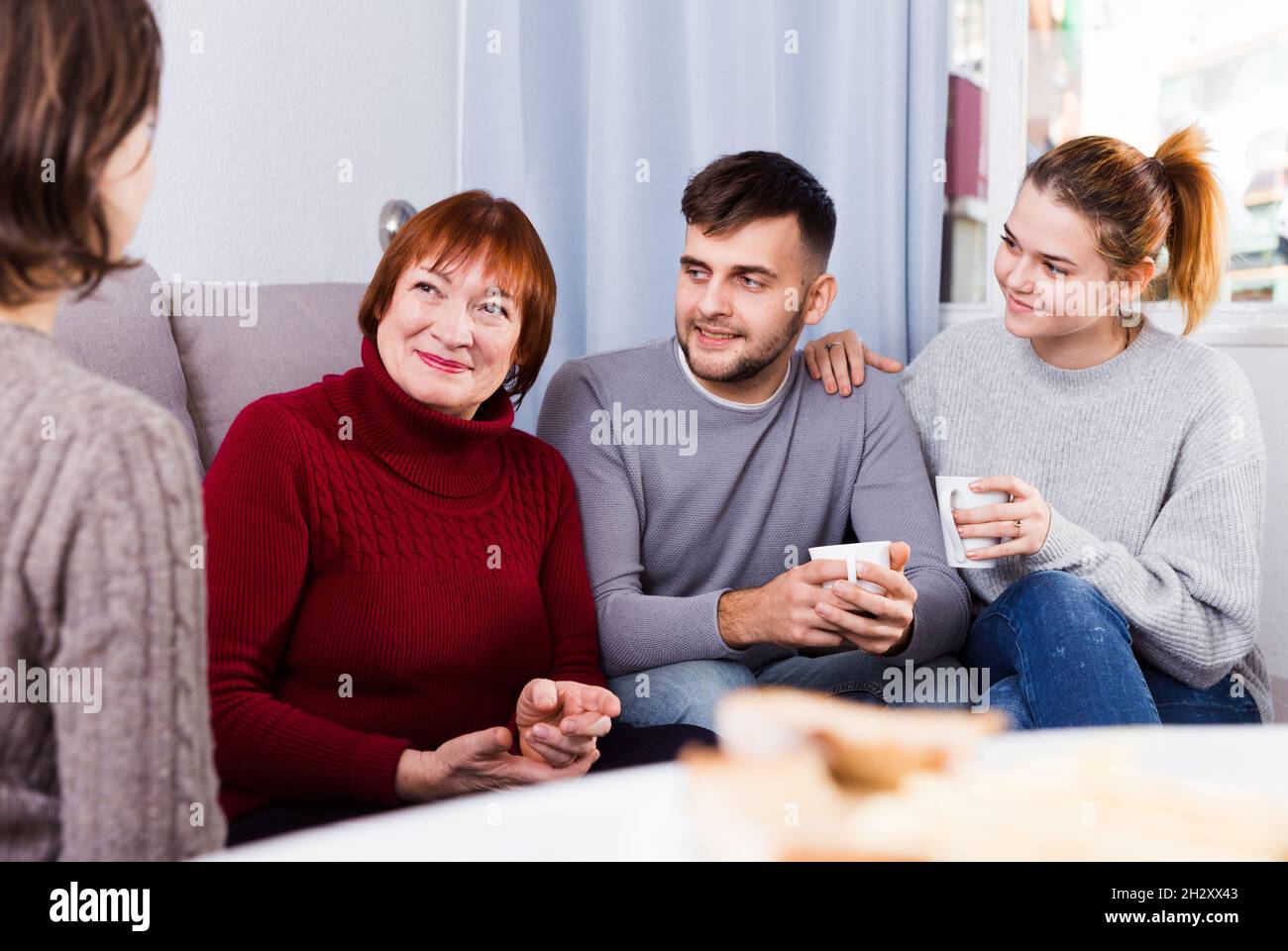 Family enjoying conversation with female Stock Photo - Alamy