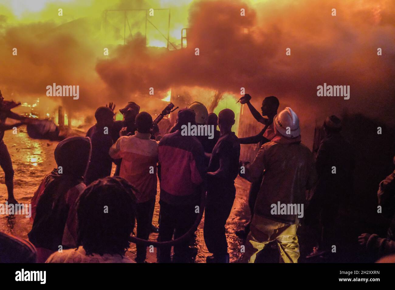 Nairobi, Kenya, 23 Oct 2021, Homeless residents and firefighters watch ...