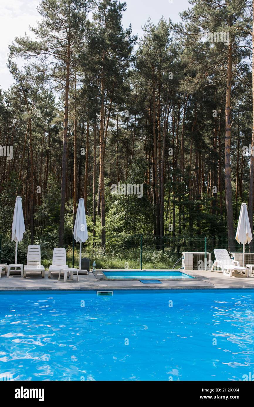 a swimming pool in the forest with umbrellas in summer Stock Photo - Alamy