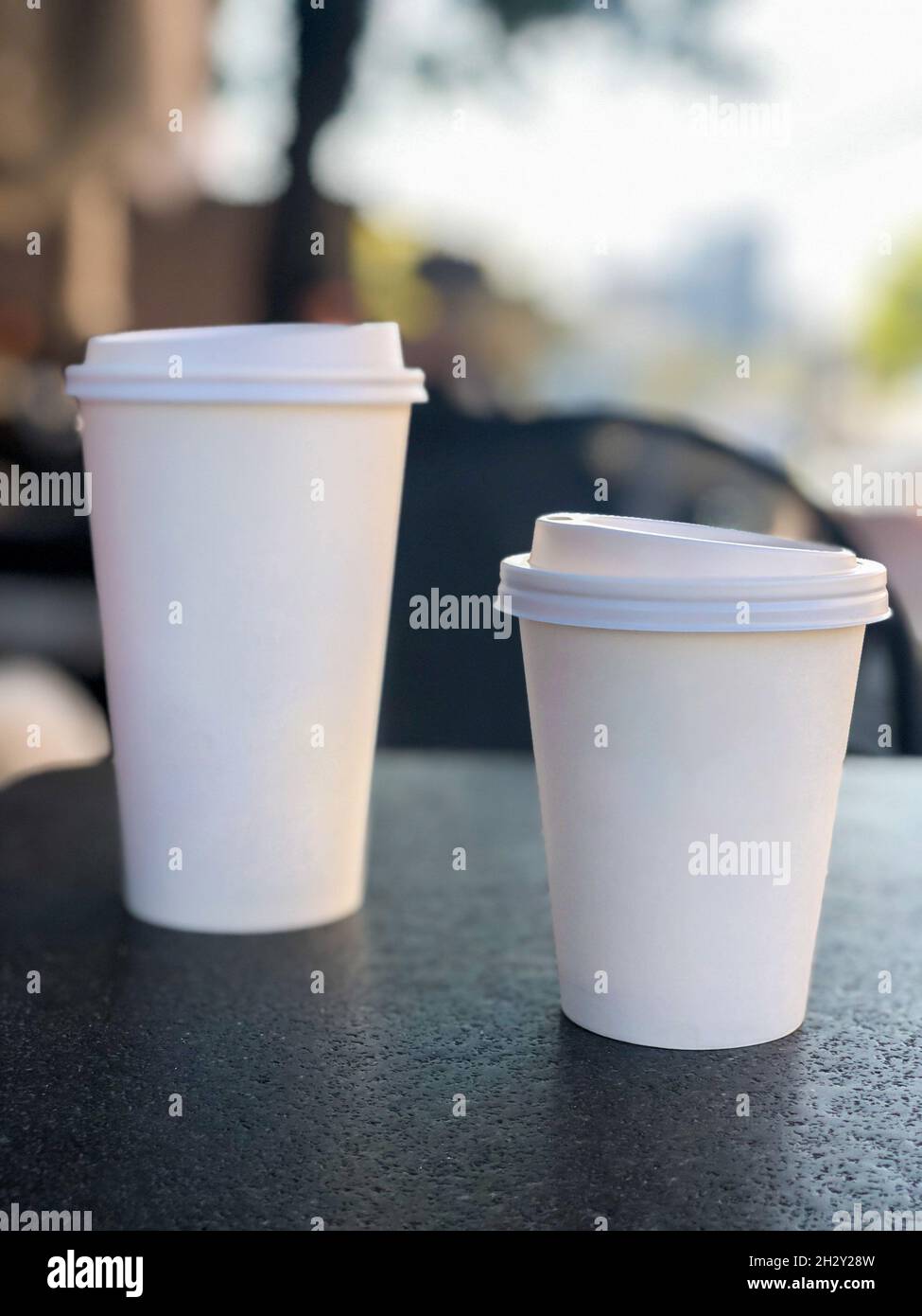two take away coffee mugs on the table in a cafe with copy space ...
