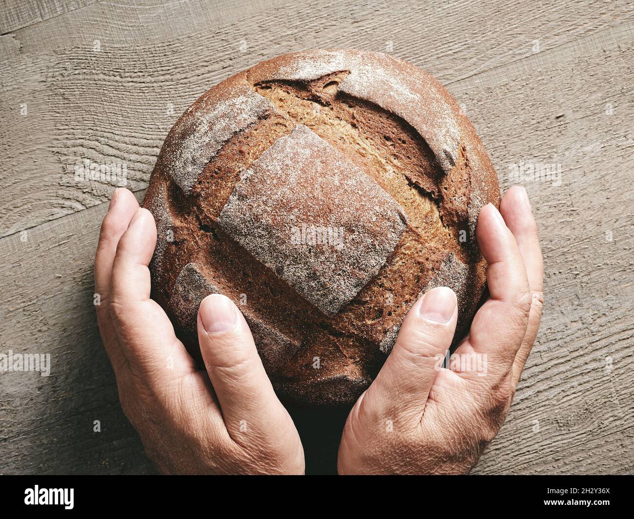 freshly baked artisan bread in human hands, top view Stock Photo - Alamy