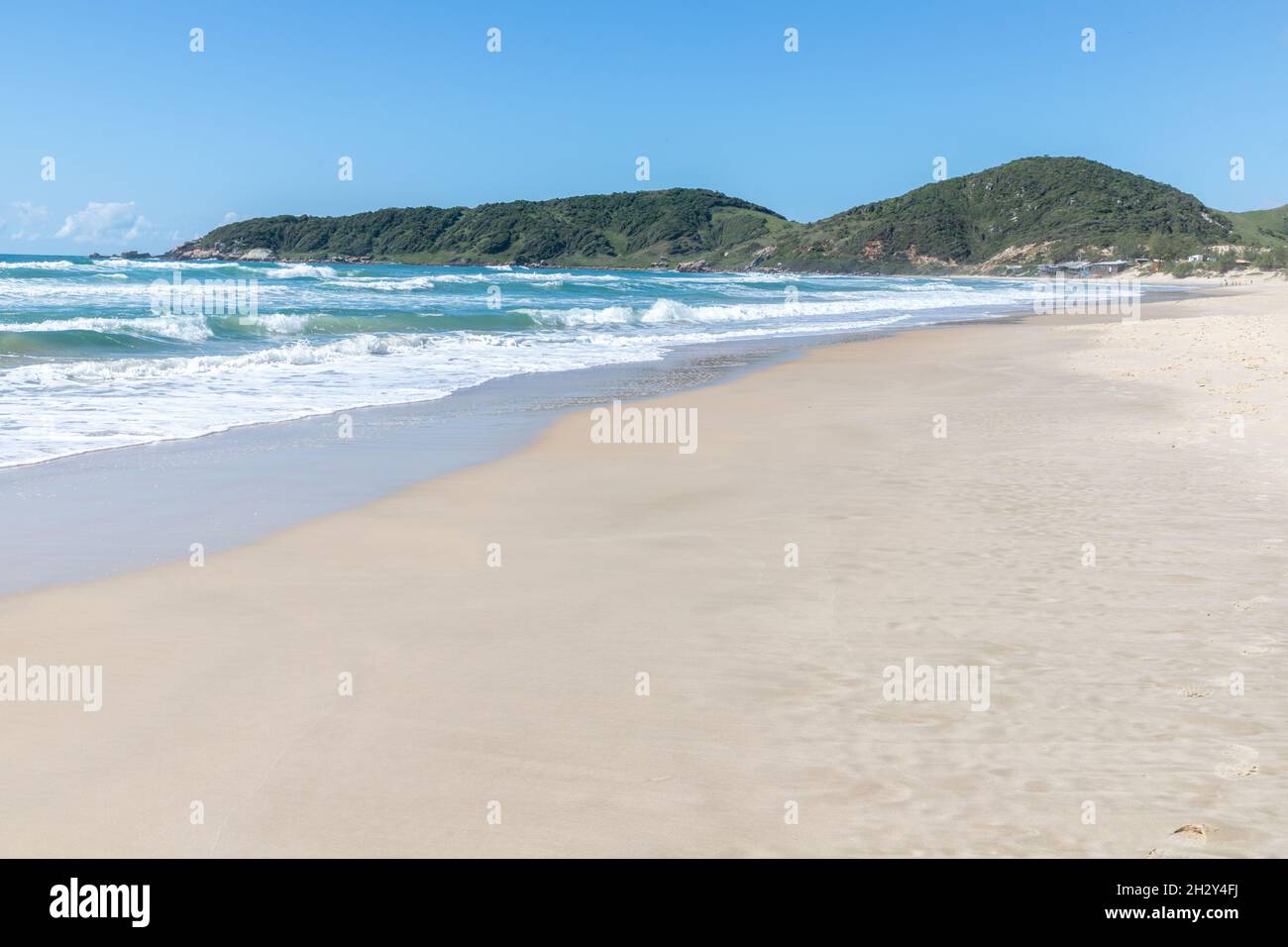 Beach with forest over mountain, sand and waves, Praia do Rosa ...