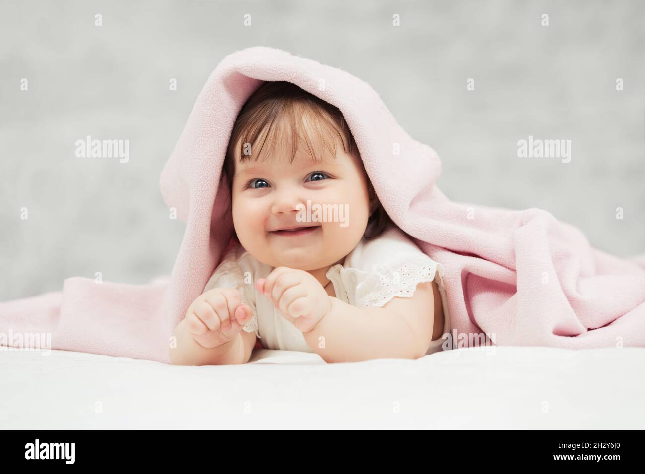 Happy six months old baby girl lying on blanket at home Stock Photo - Alamy
