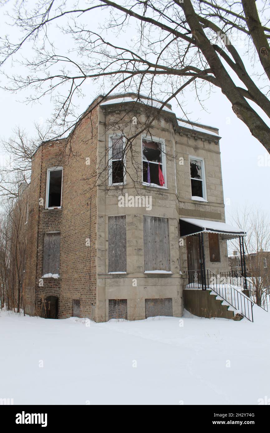 Abandoned and boarded-up graystone two flat in Englewood in snow in ...