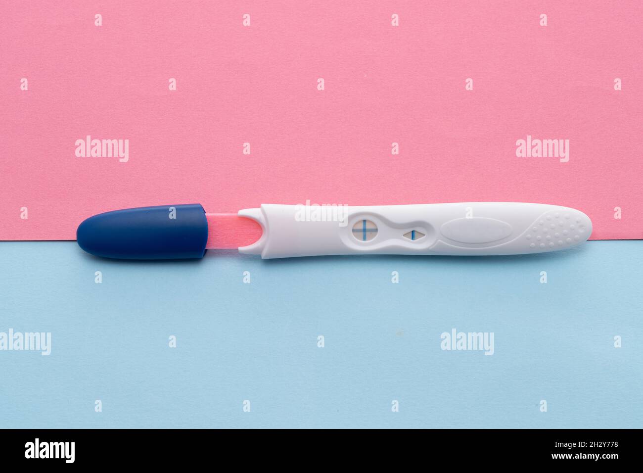 A pregnancy test stick showing a positive result - blue and pink ...