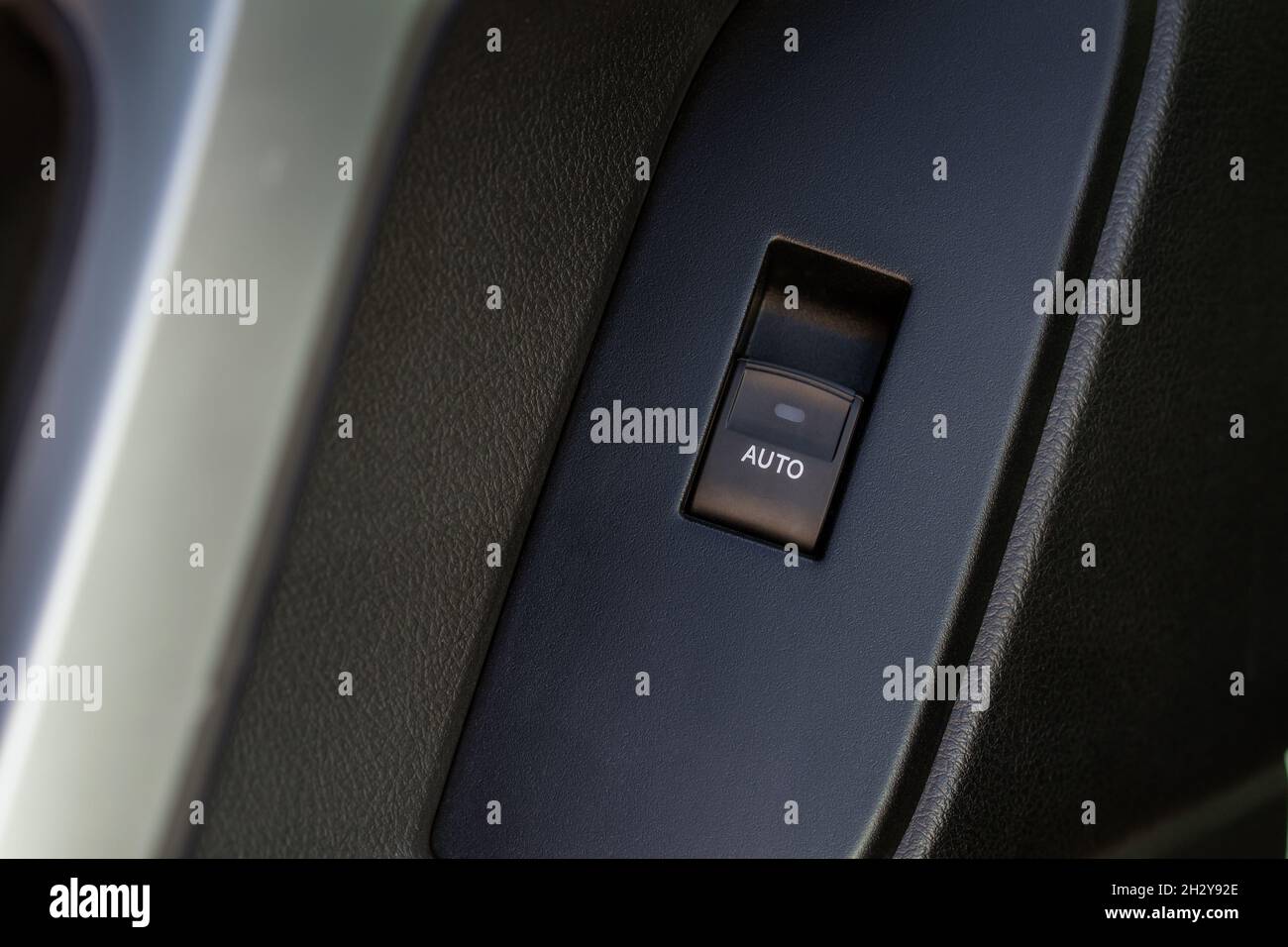 Car door handle with power window control. Dark leather interior of ...