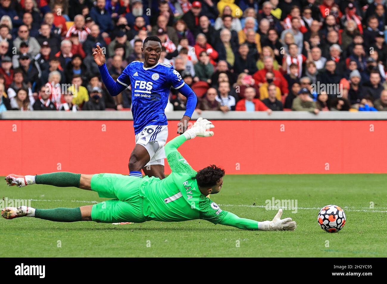 Patson Daka #29 of Leicester City slips the ball past David Raya #1 of ...