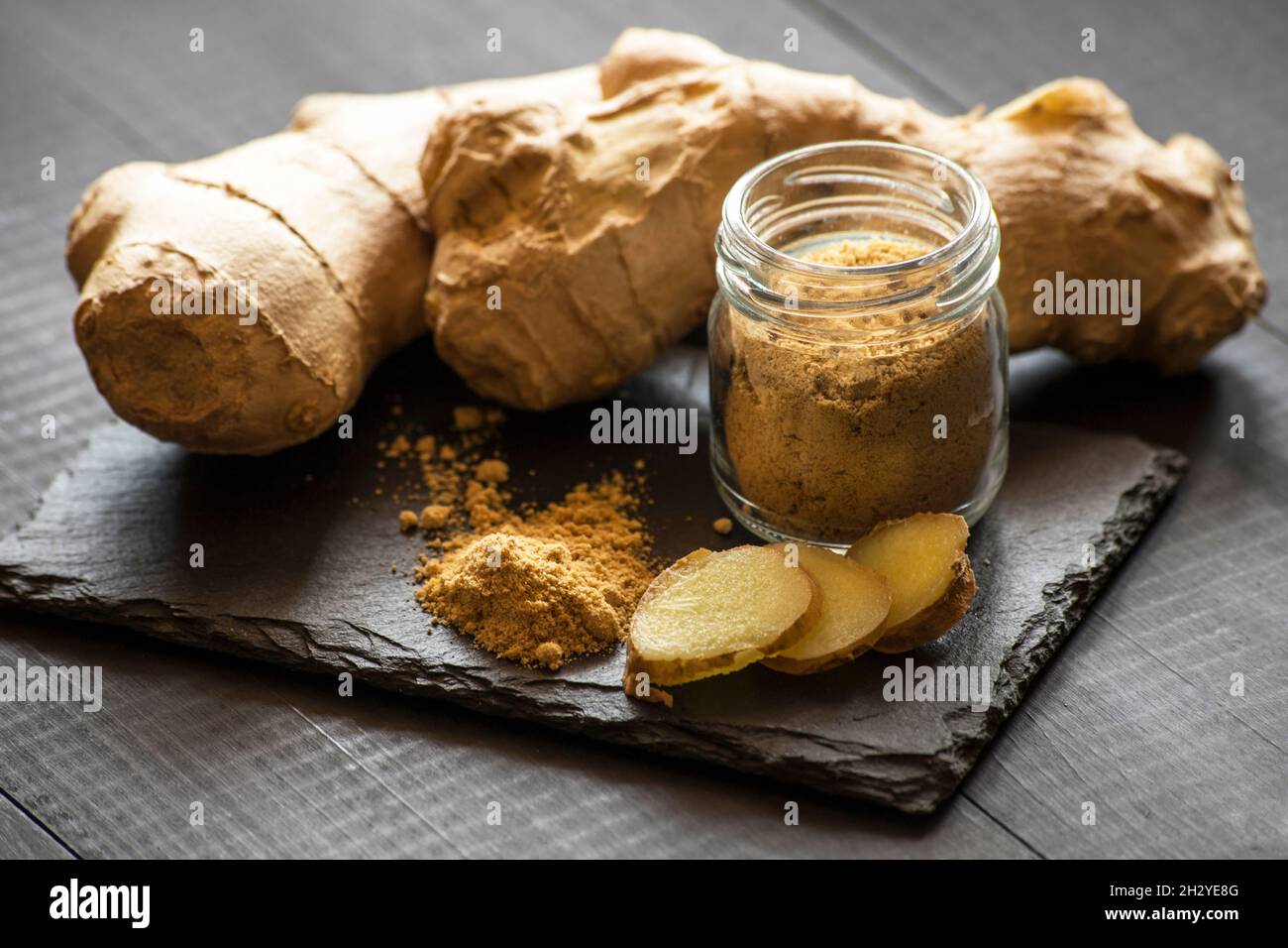 ginger root and powder on black stone plate Stock Photo - Alamy