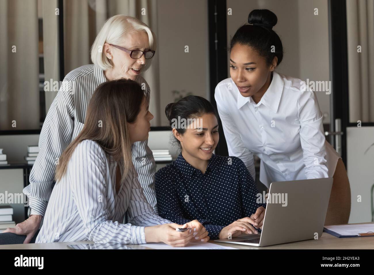 Friendly multiracial corporate female team collaborate at office ...