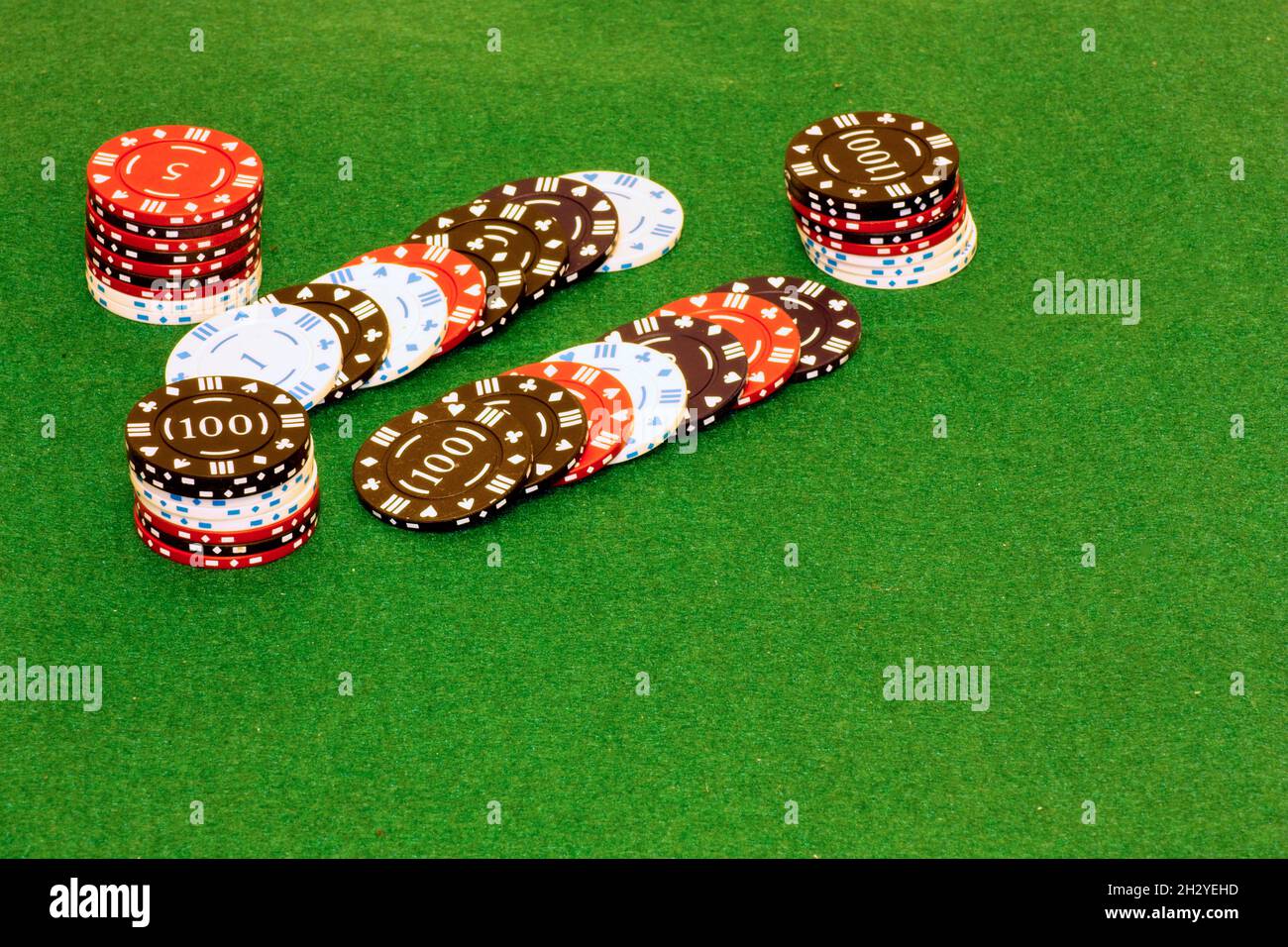 Piles of gambling tokens on a green background Stock Photo - Alamy