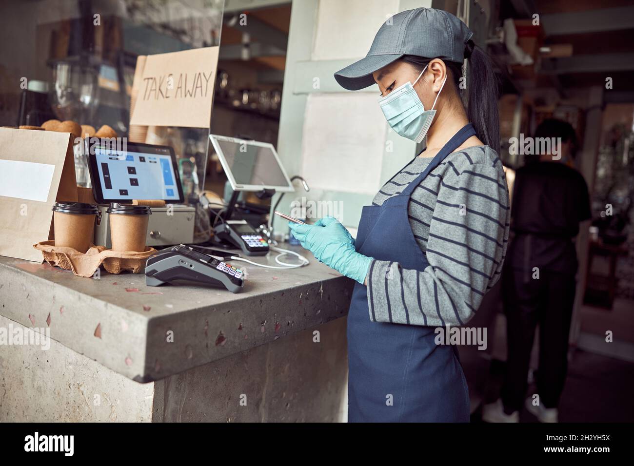 Female cafe worker checking online orders indoors Stock Photo - Alamy