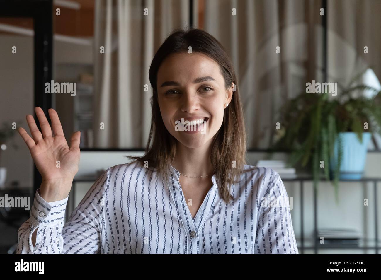 Screen portrait of smiling female presenter wave hand to camera Stock ...
