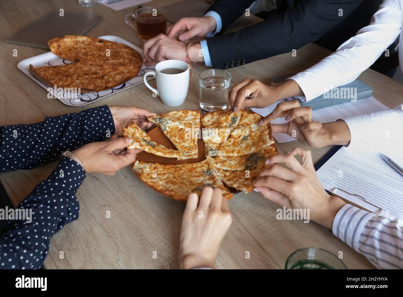 Diverse Businesspeople Colleagues Eating Pizza At Workplace On Lunch
