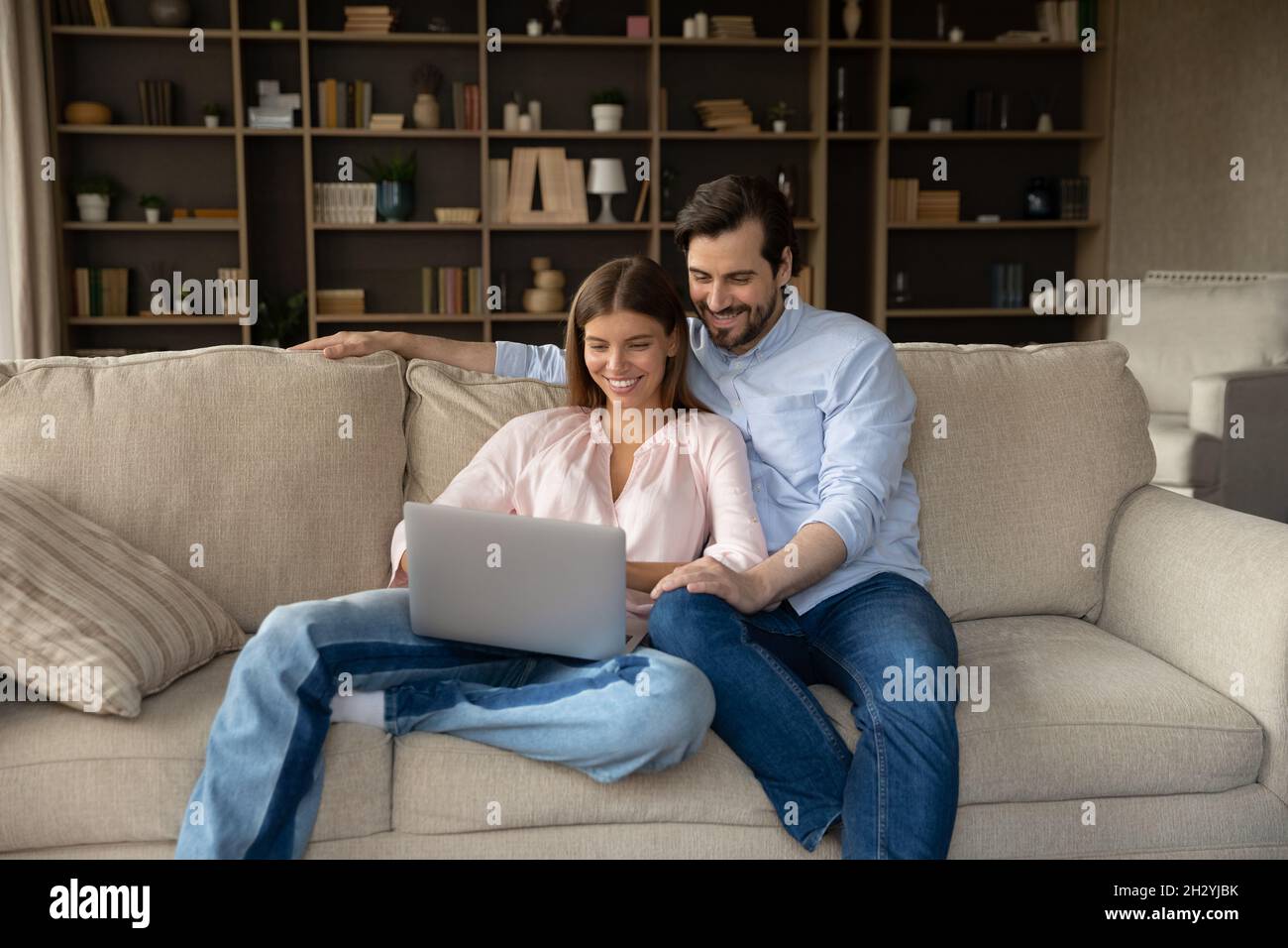 Happy young family couple using computer at home Stock Photo - Alamy