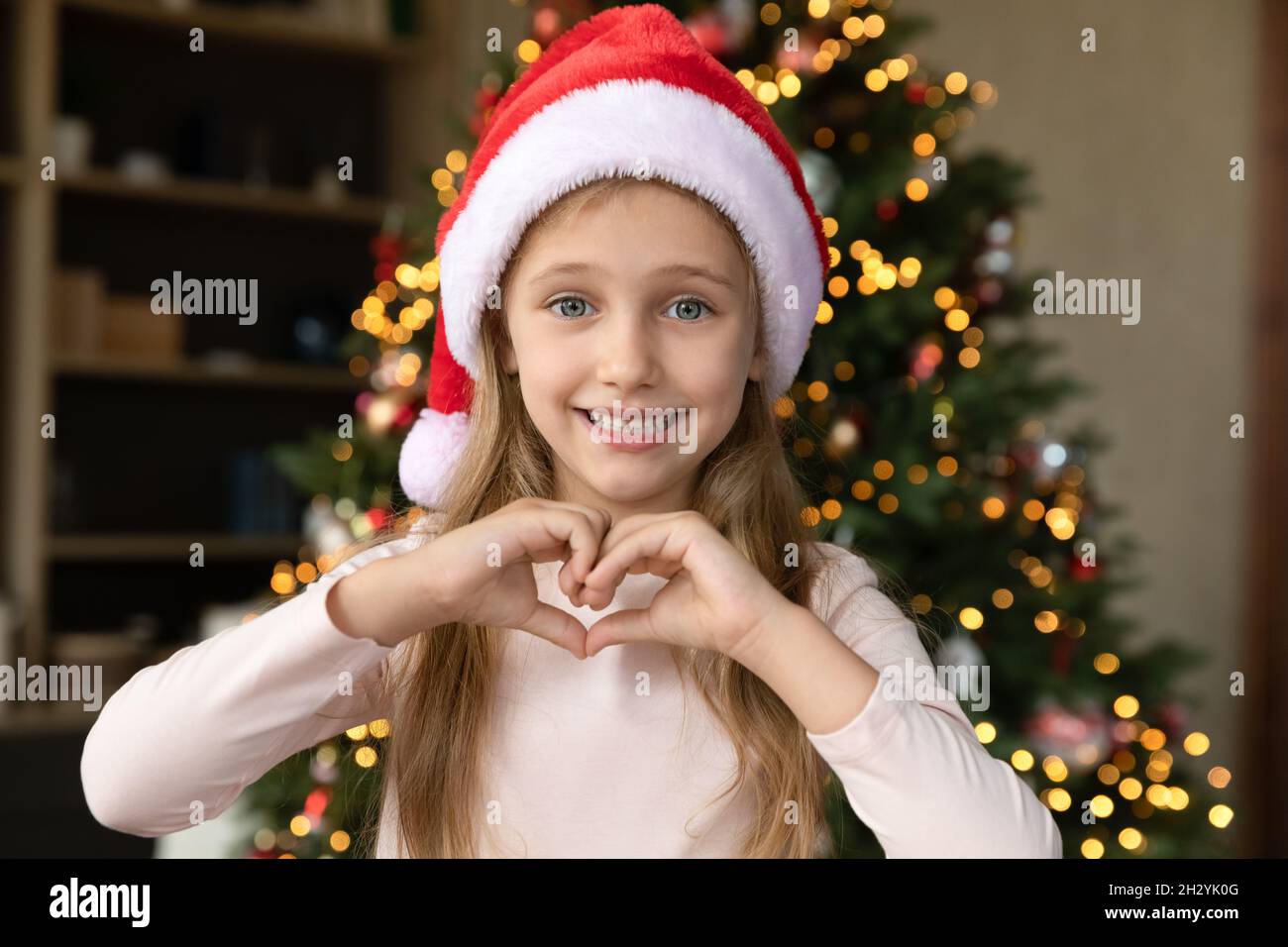 Happy cute little girl showing love sign Stock Photo - Alamy
