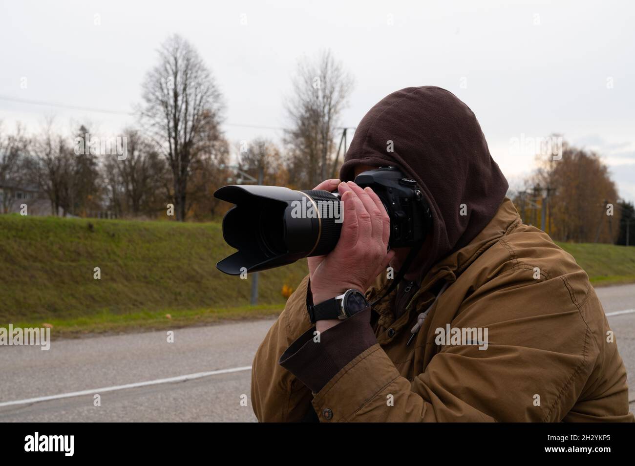Close-up of a photographer shooting a city view in the cold autumn ...