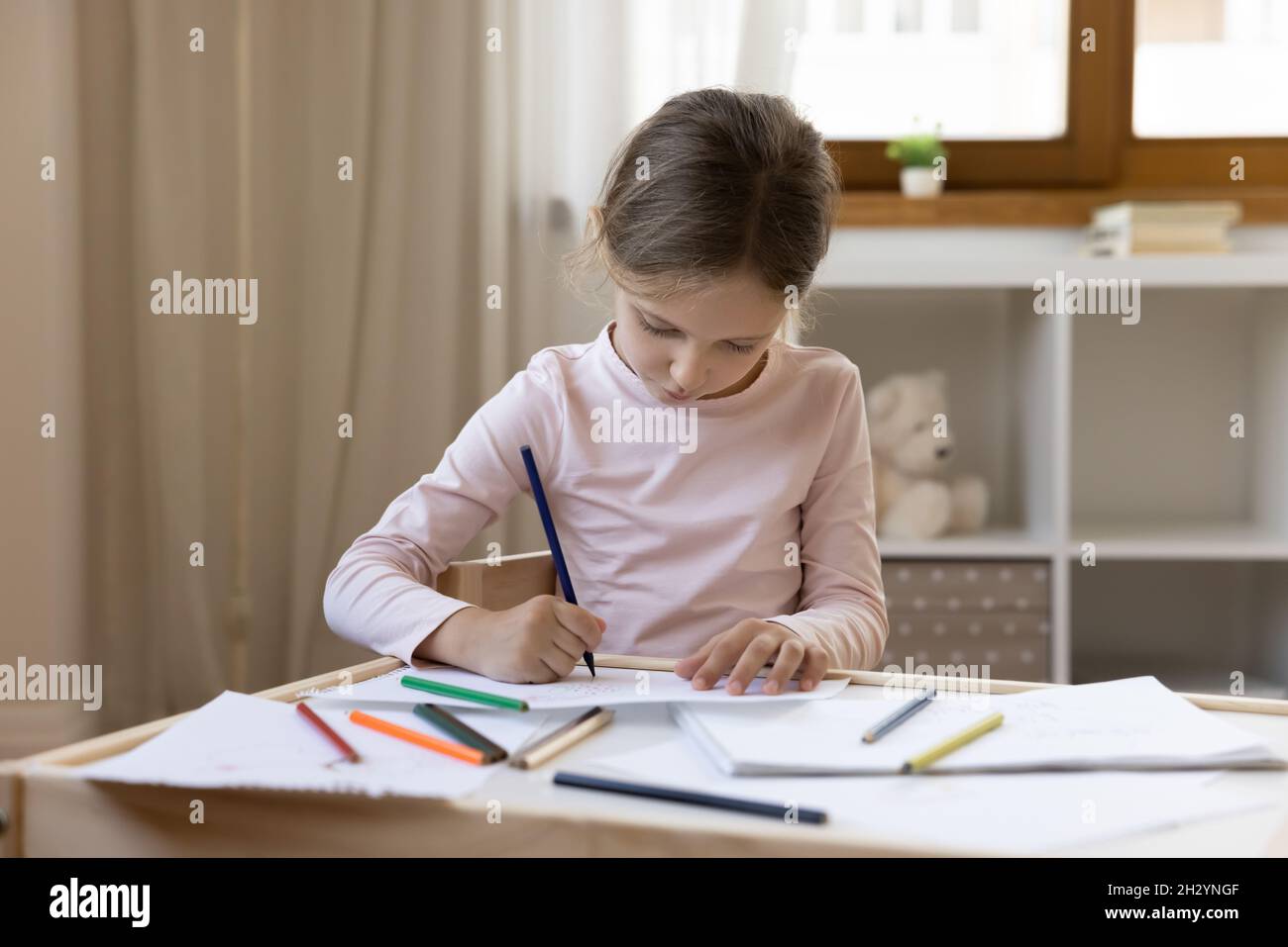 Adorable small girl drawing pictures on paper Stock Photo - Alamy